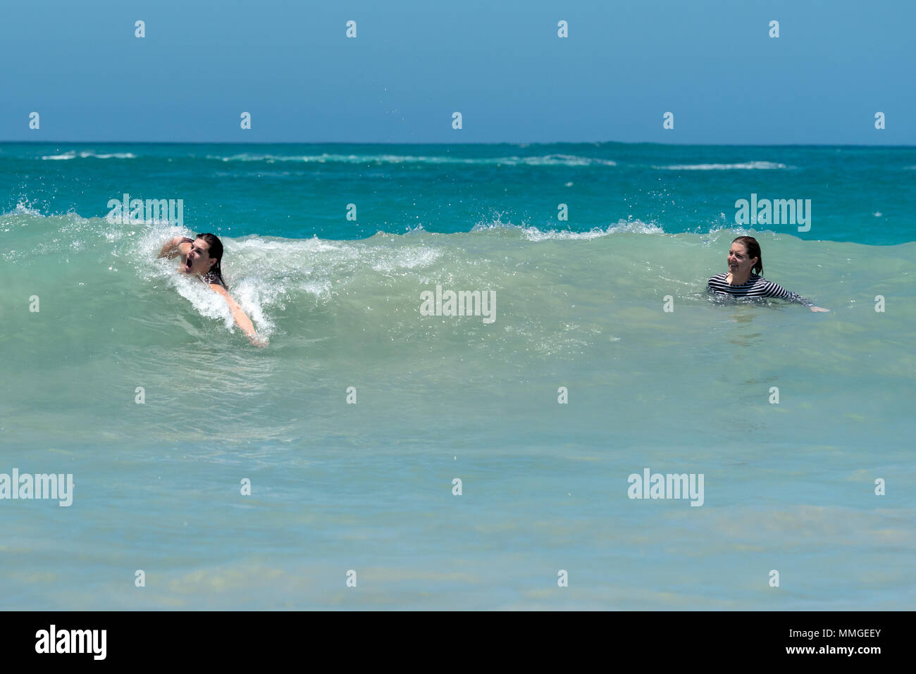 Women body surfing on a beach on Isabel Island in the Galapagos Islands ...
