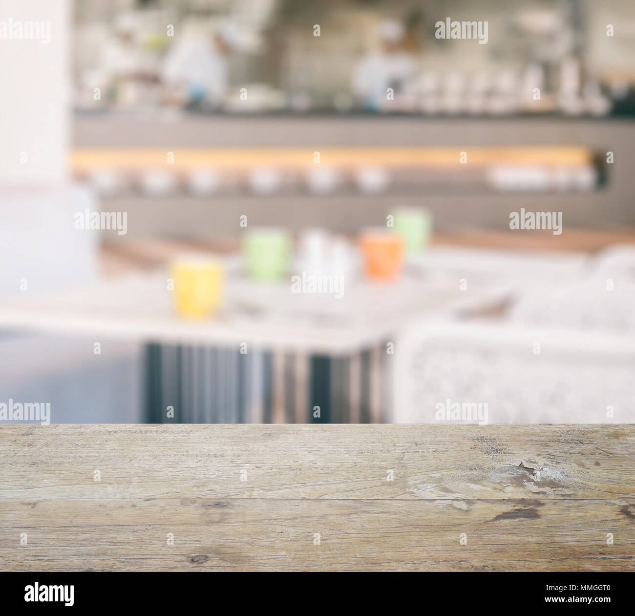 wooden table top with restaurant interior and colorful tables set for ...