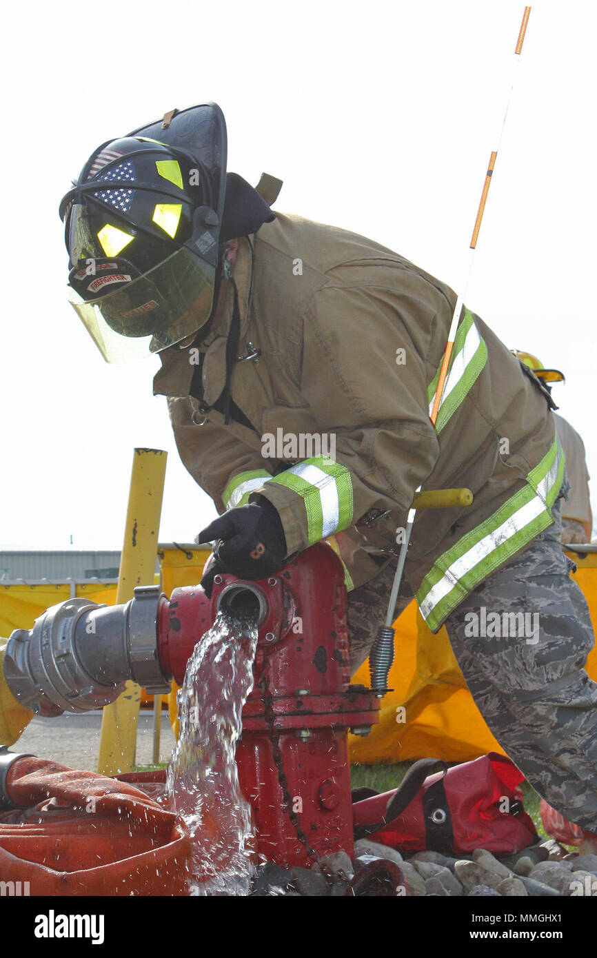 Senior Airman Jason Collier opens a fire hydrant during a training ...