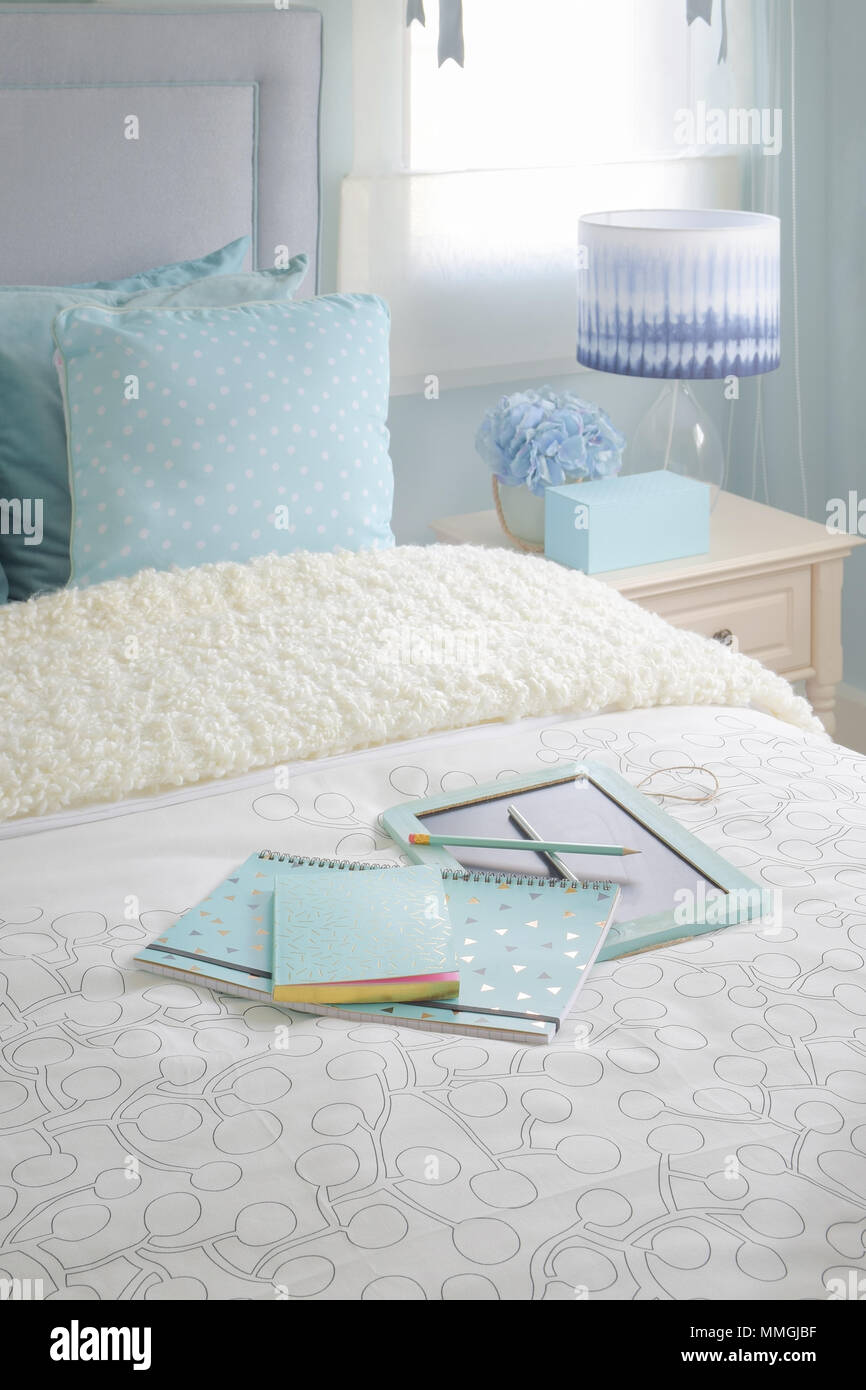 Blue color notebook on bed in light blue color scheme bedroom interior ...