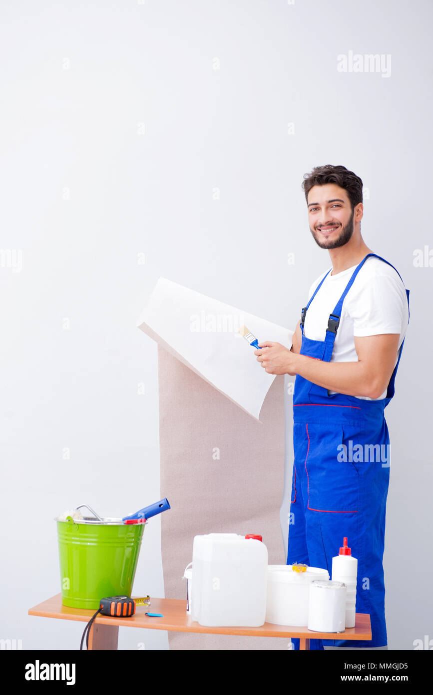 Worker working on wallpaper during refurbishment Stock Photo - Alamy