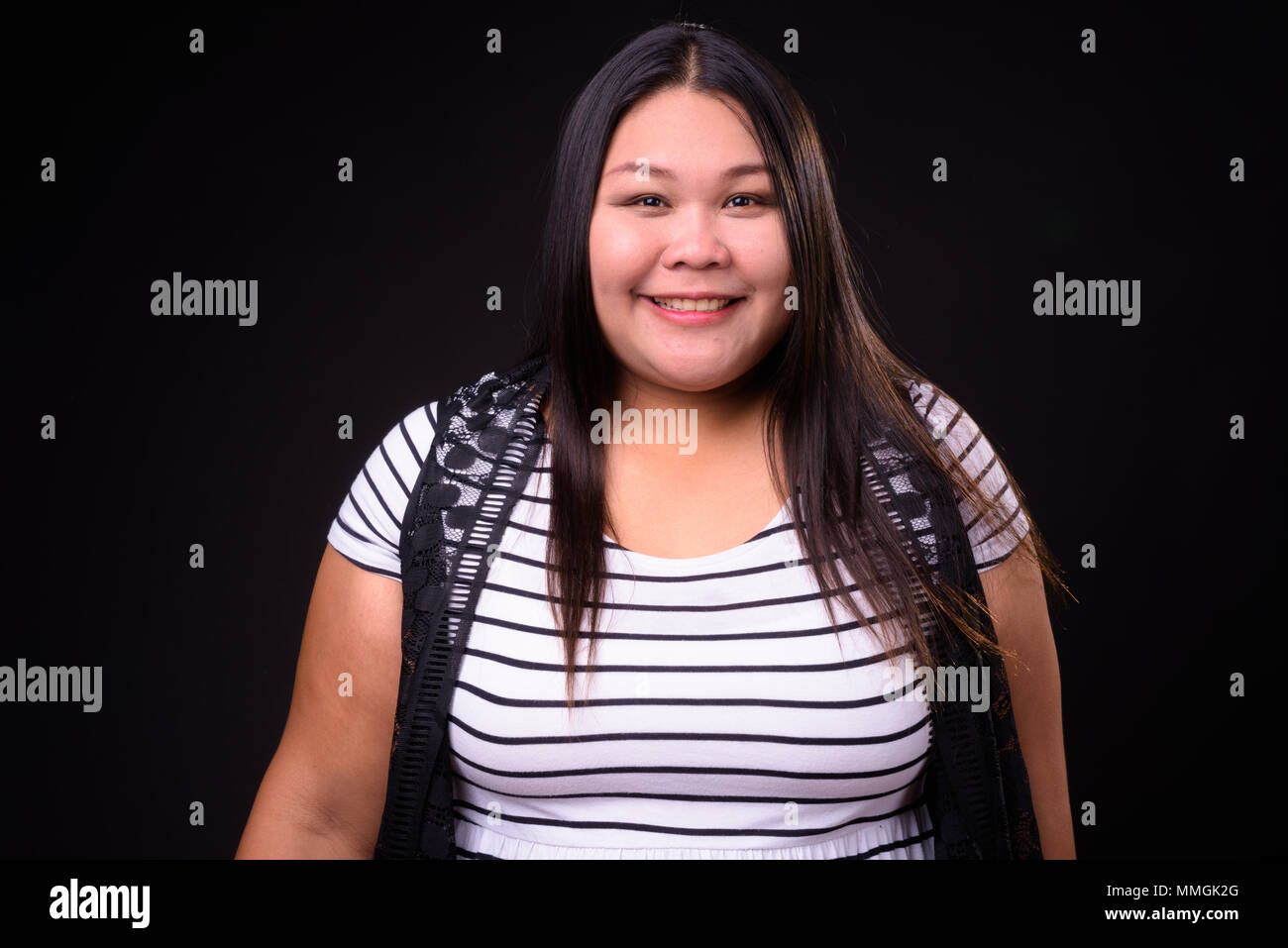 Beautiful overweight Asian woman against black background Stock Photo ...