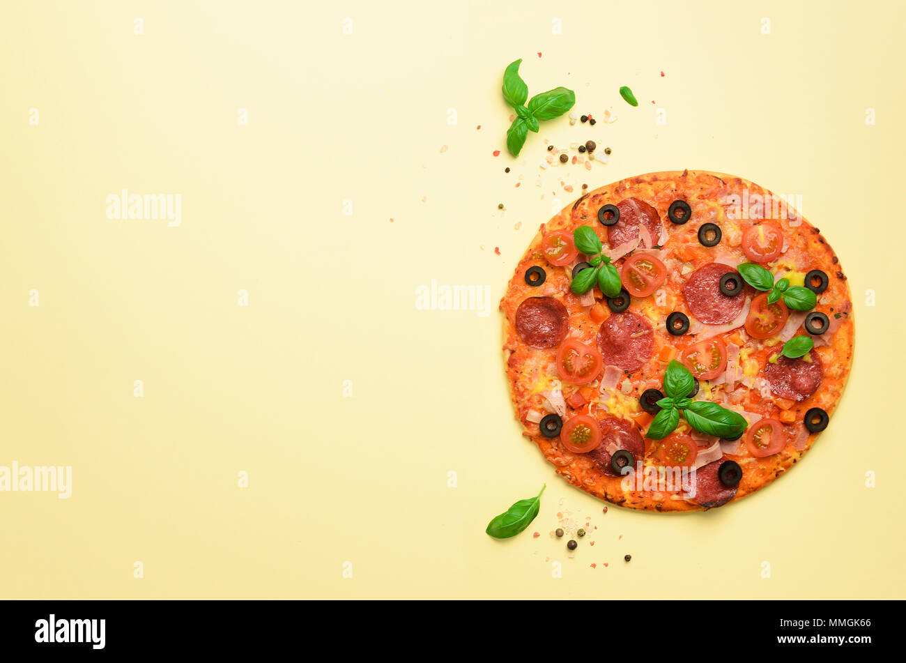 Delicious italian pizza, basil leaves, salt, pepper on yellow ...