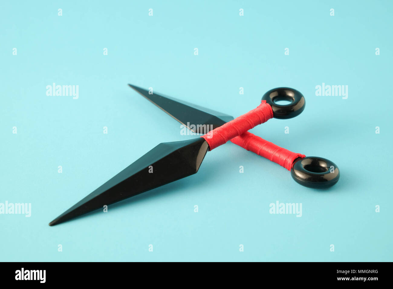 To throw ninja weapons isolated on blue paper background Stock Photo ...