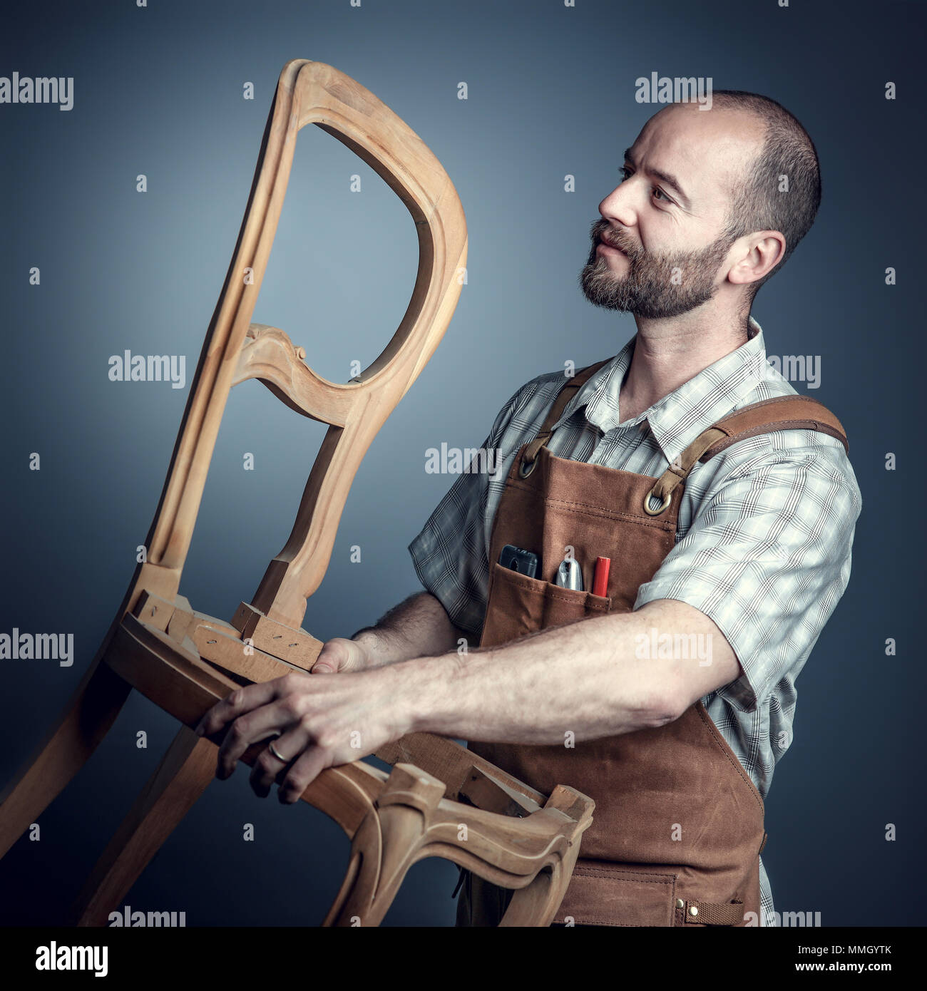 portrait of carpente holding unfinished chair studio shot Stock Photo ...