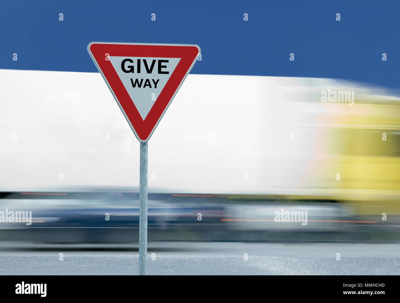 Give way text yield road sign and truck in the background, traffic ...