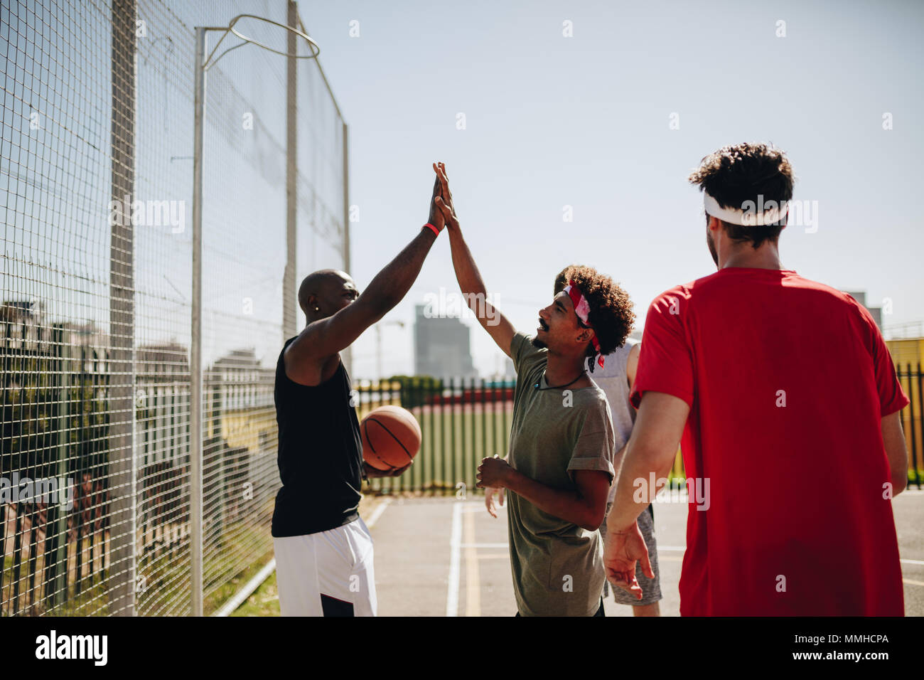 Basketball men celebrating after scoring points. Teammates giving high ...