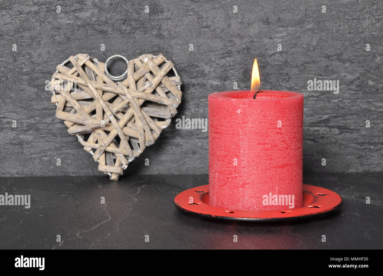 Burning candle and heart on shale Stock Photo - Alamy