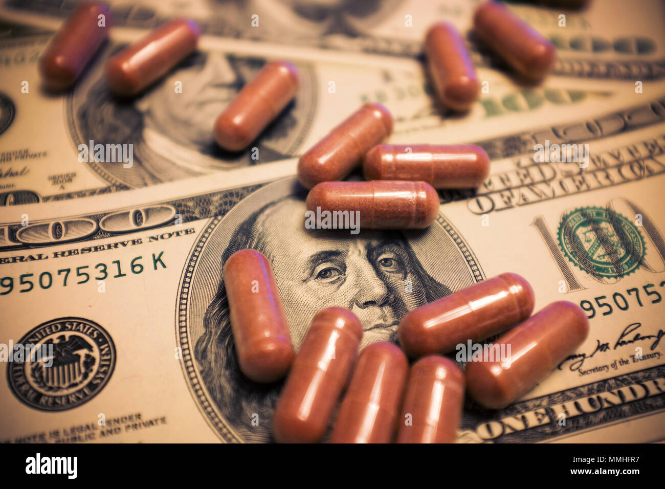 Capsule on the one hundred dollars bills Stock Photo - Alamy