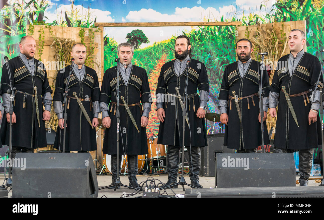 six singers in Georgian traditional costumes standing on scene of the ...