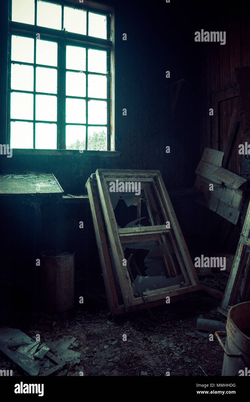 window light into a dilapidated shed, containing rusty items and broken ...