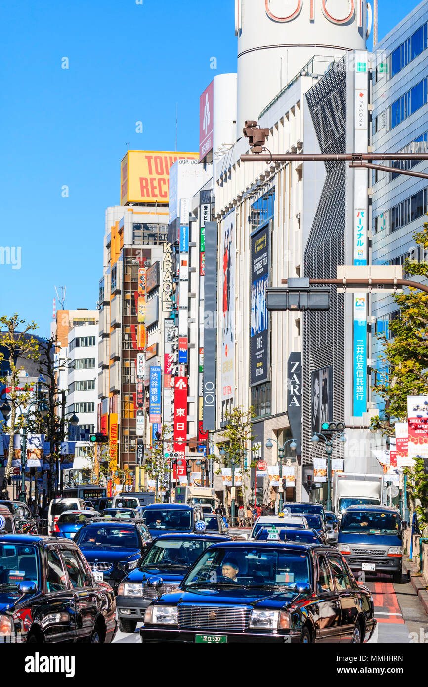 Tokyo, Shibuya crossing. View along one main street with traffic, solid ...