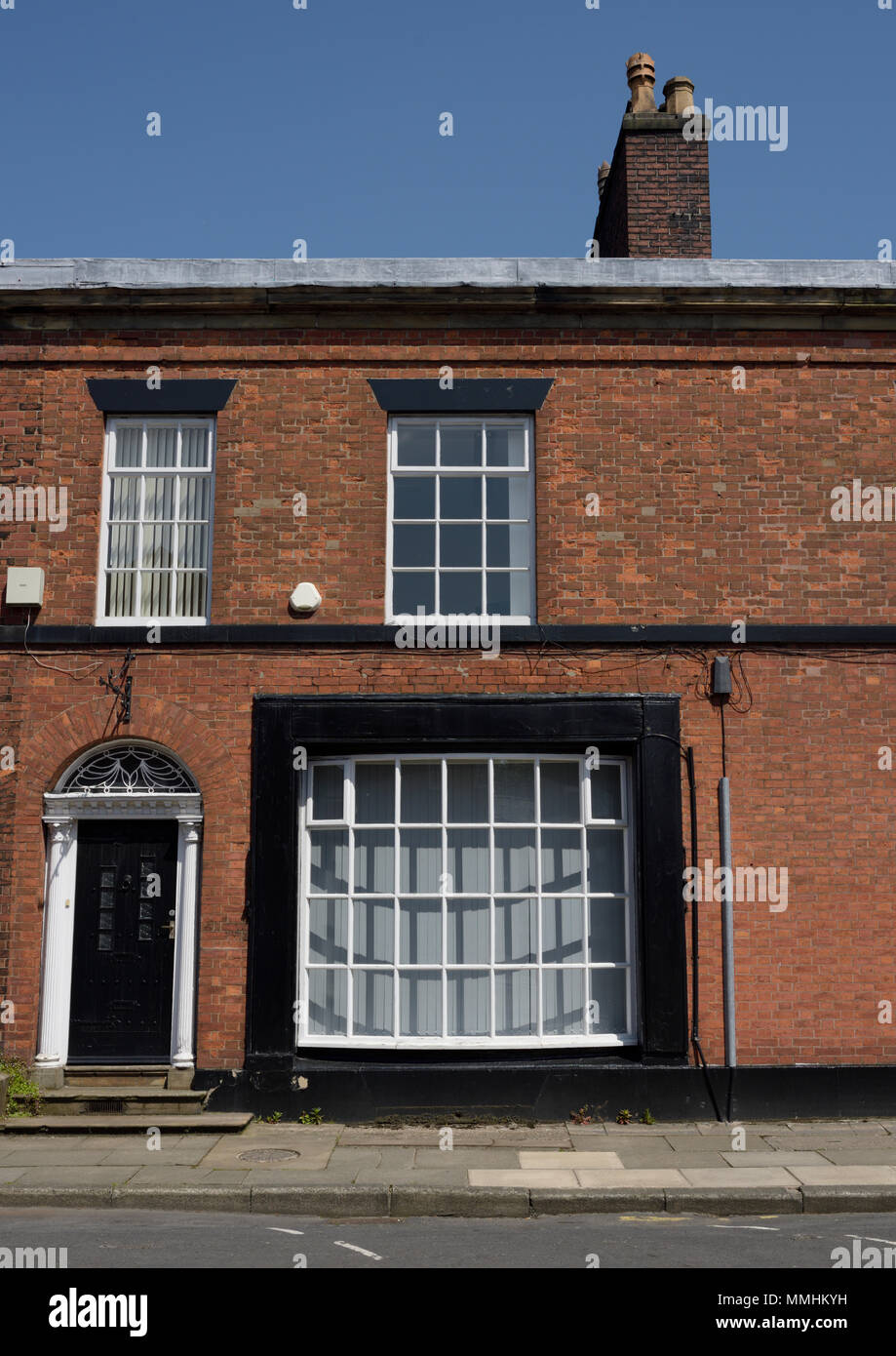 Red brick two storey terraced house with white wooden window frame and ...