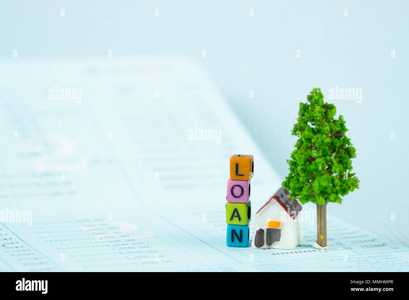 LOAN text and small model house and little tree with notebook, savings ...