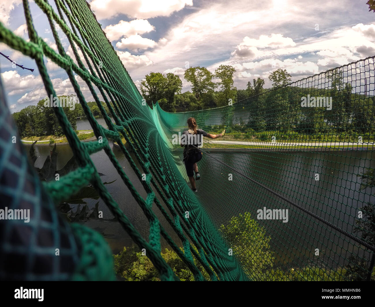 Young girl climbs on a high ropes course Stock Photo - Alamy