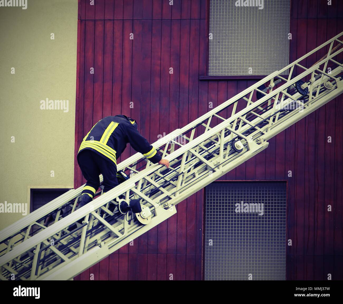 One fireman walks on the aerial ladder with vintage effect Stock Photo ...