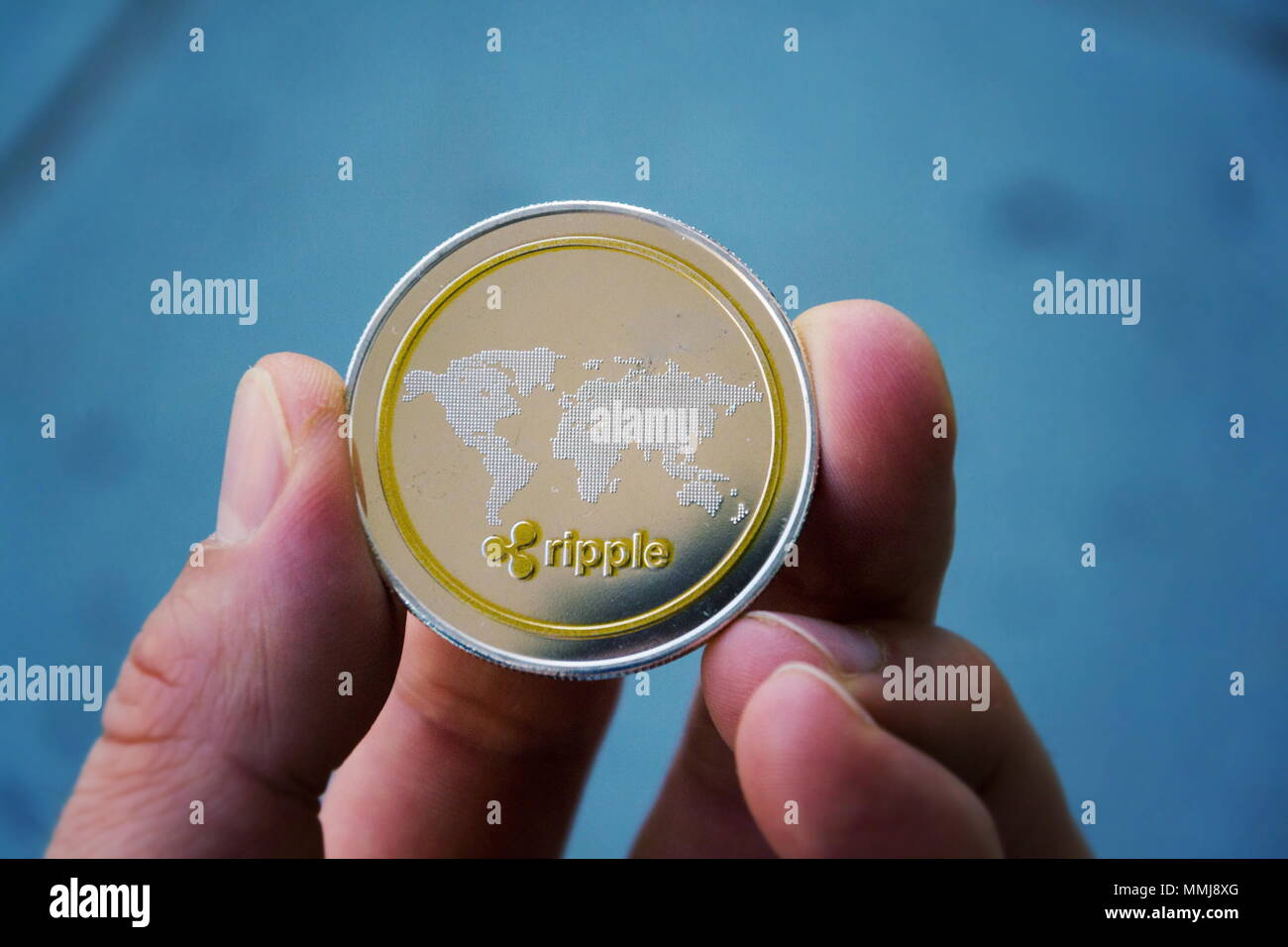Silver gold ripple coin in hand, cryptocurrency investing concept Stock ...