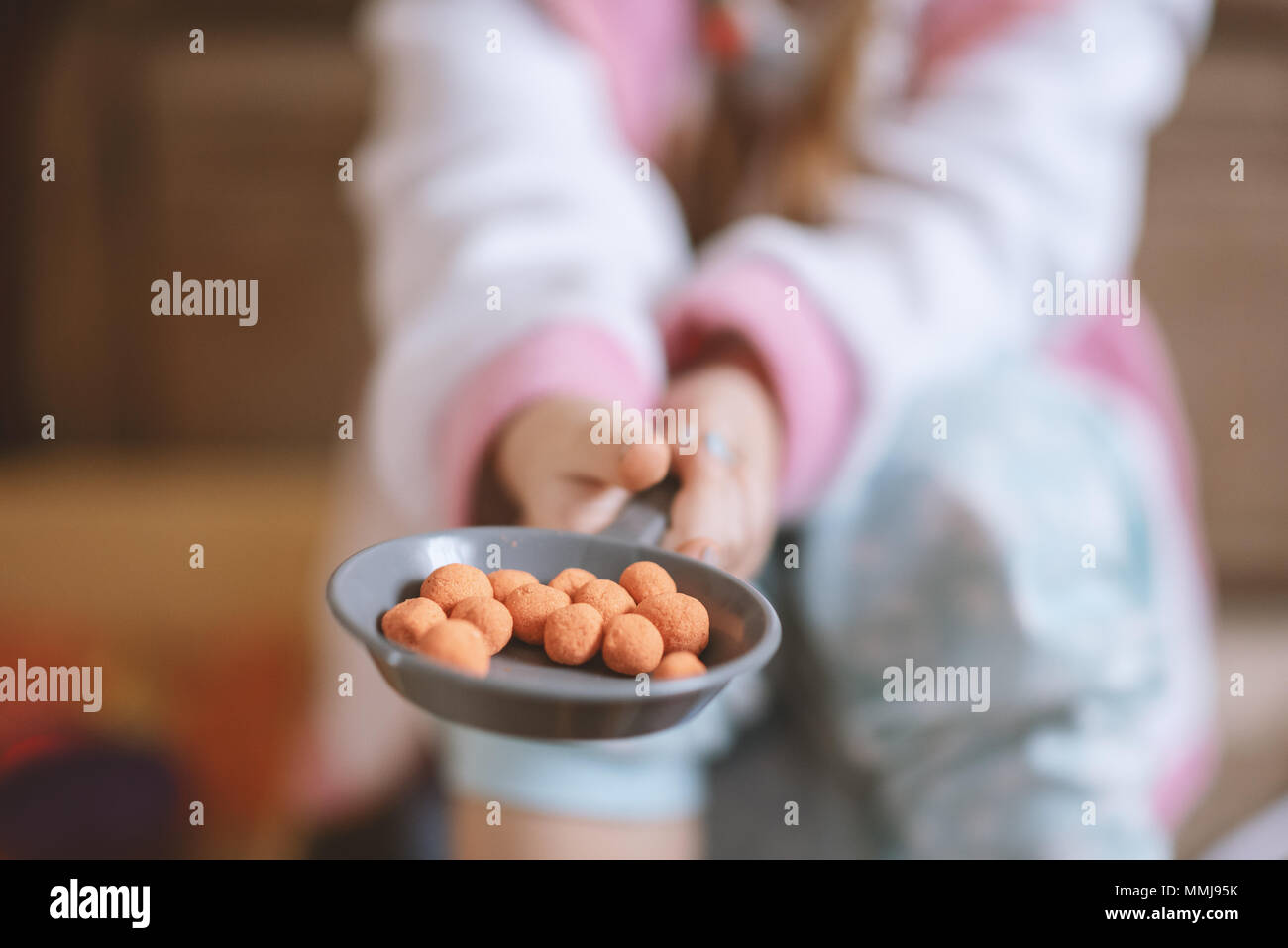 Little girl holds on the game frying pan kinetic sand, cooking game ...