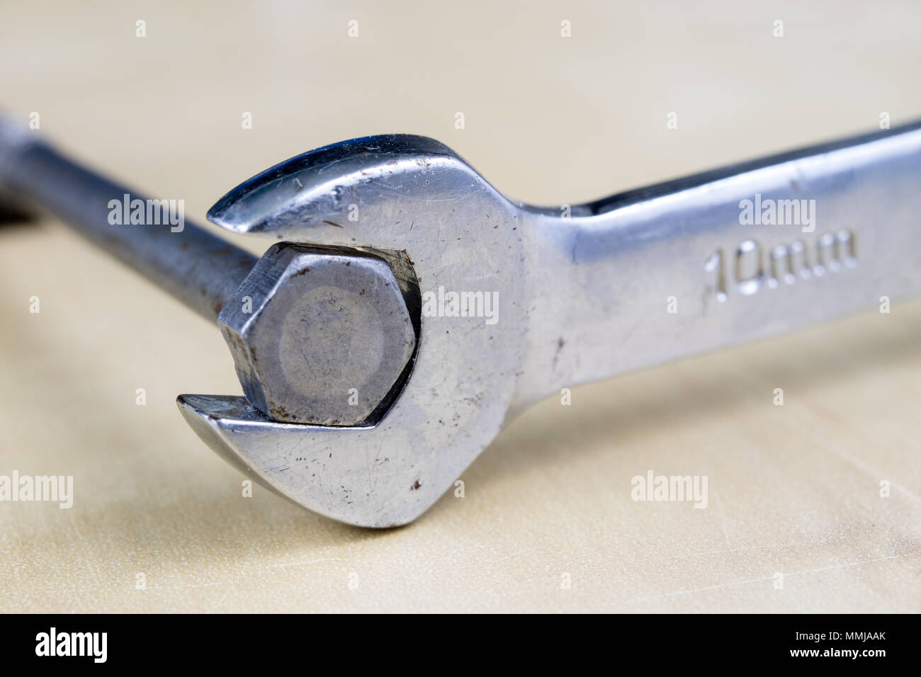 Metric screw and key on a wooden table. Mechanical accessories in the ...