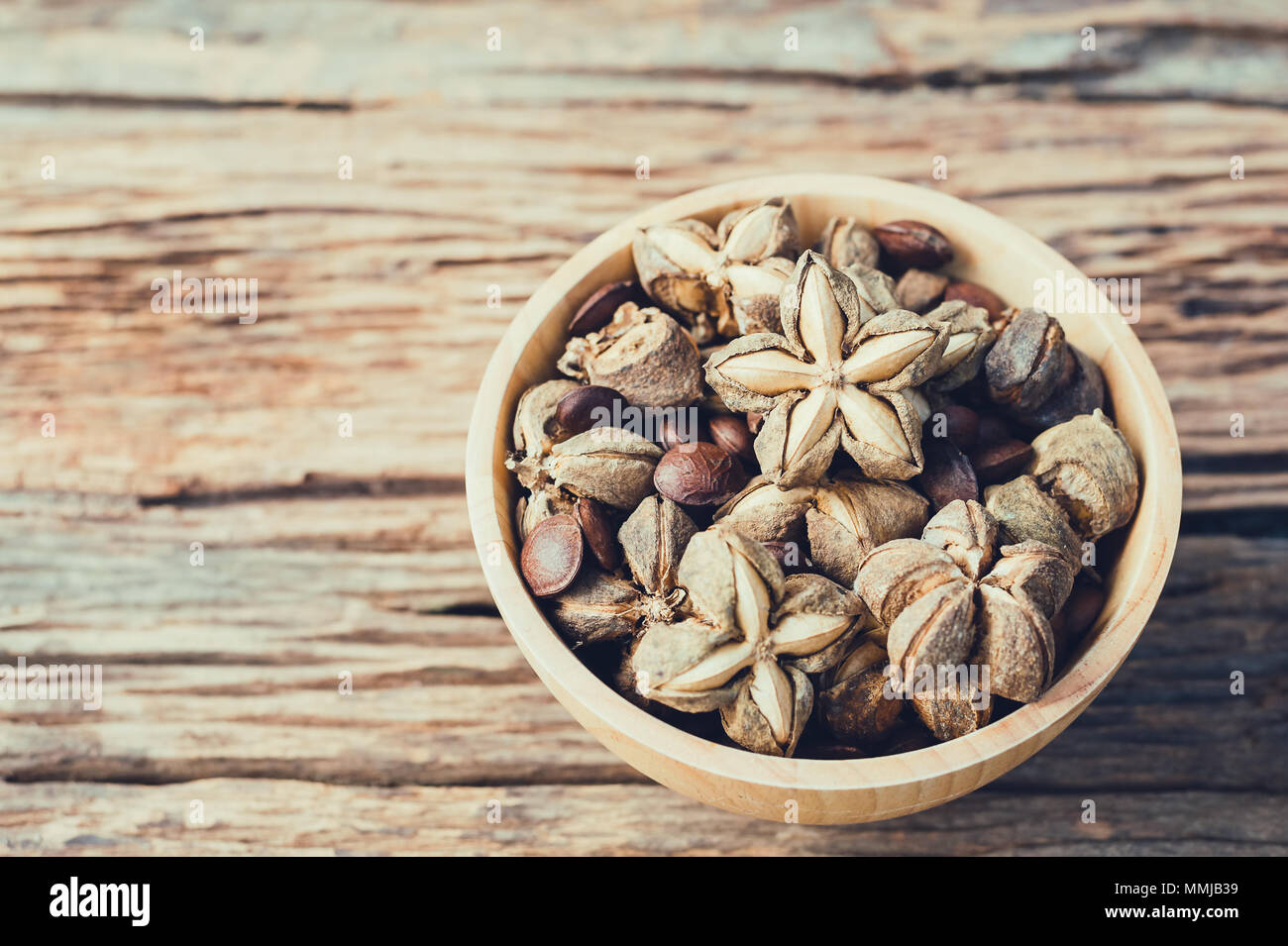 Dry sacha inchi seeds in wooden bowl on decay wood table background ...