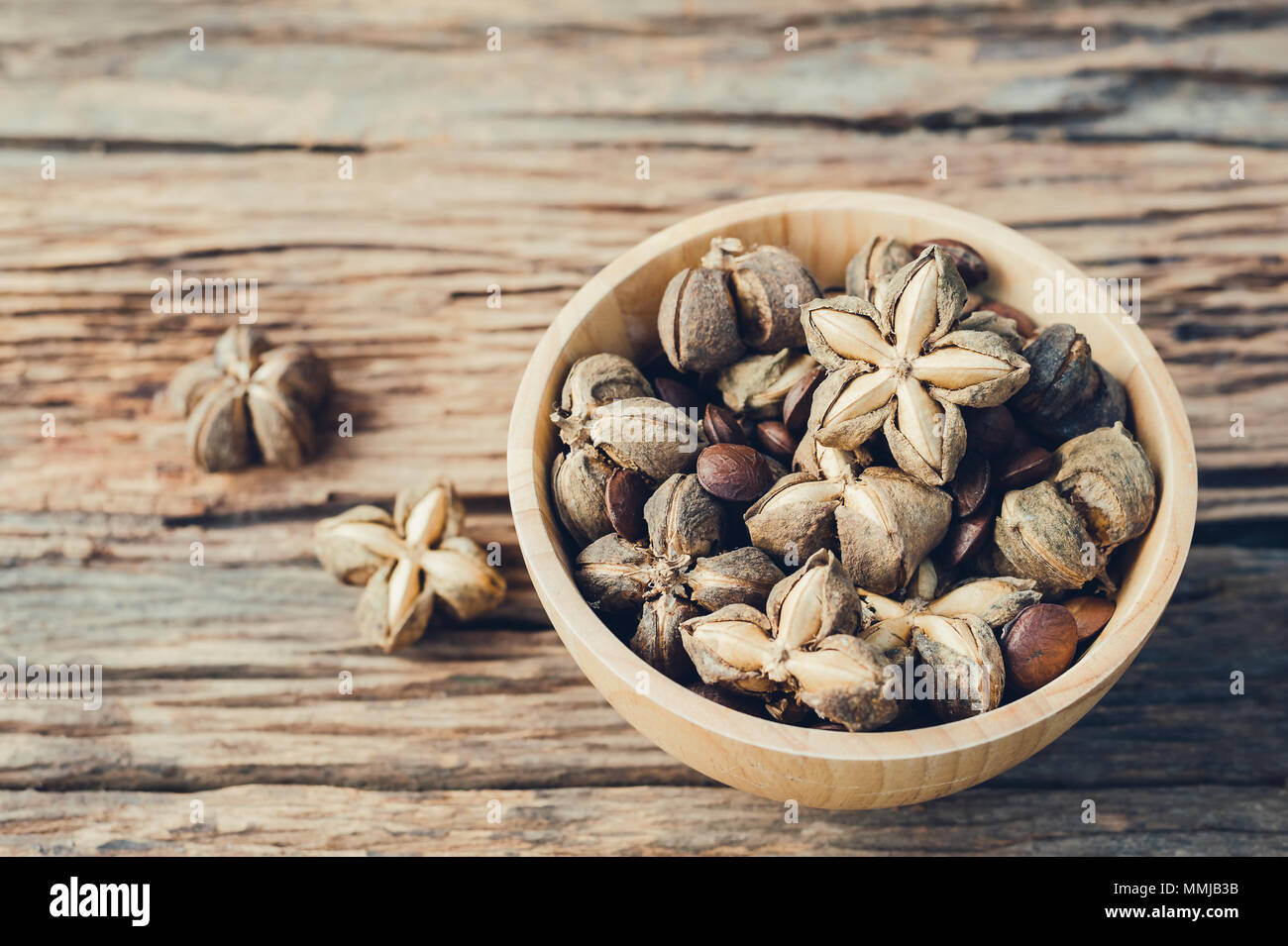 Dry sacha inchi seeds in wooden bowl on decay wood table background ...