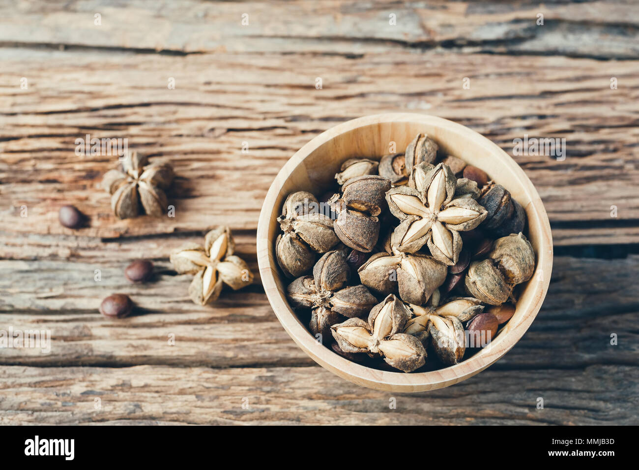 Dry sacha inchi seeds in wooden bowl on decay wood table background ...