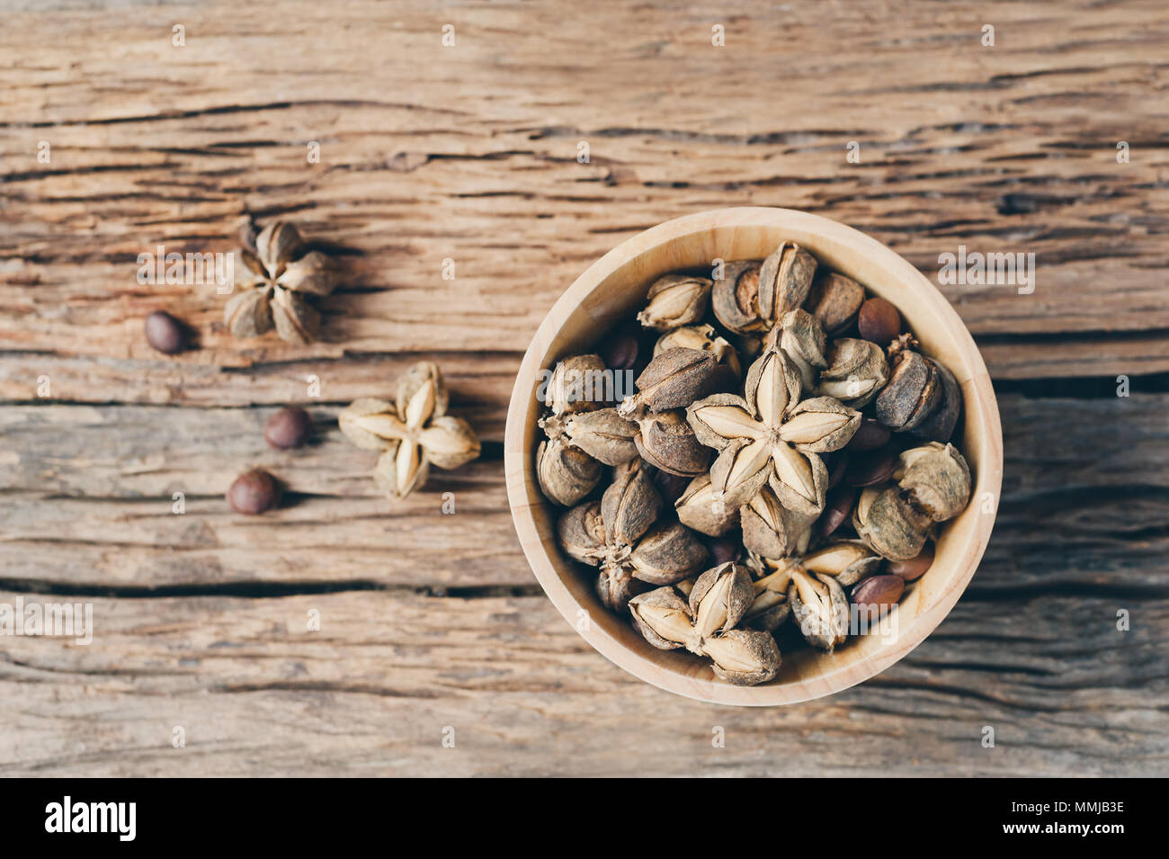 Dry sacha inchi seeds in wooden bowl on decay wood table background ...