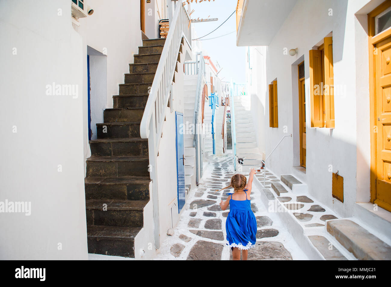 Little cute girl outdoors in old greek village. Kid at street of ...