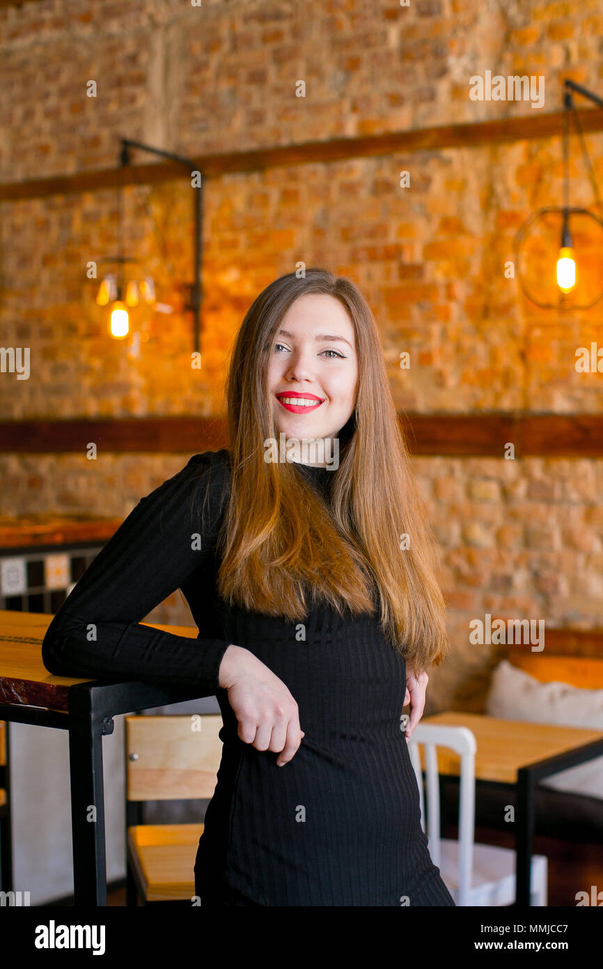 Girl sitting near table in cafe Stock Photo - Alamy