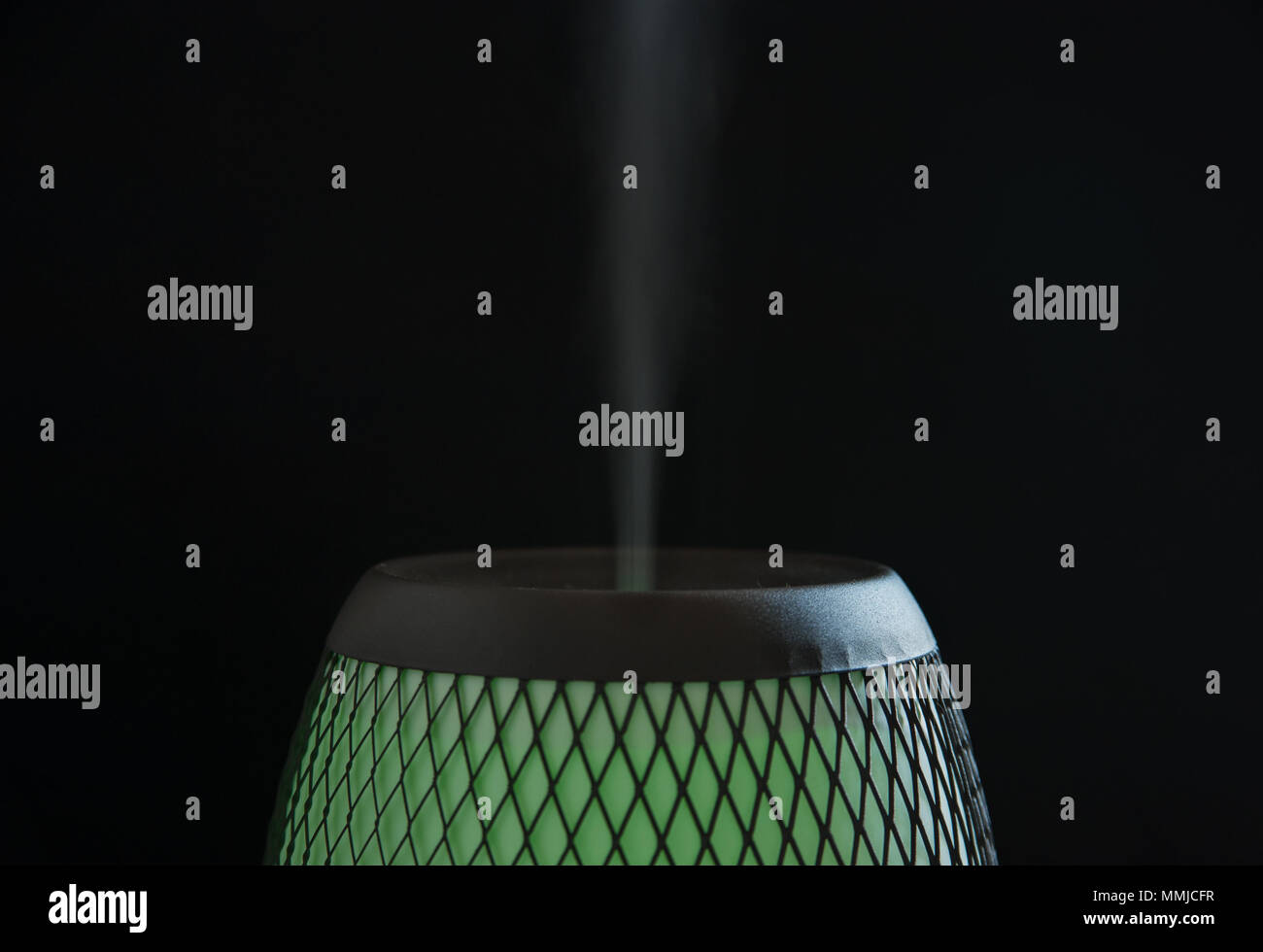 Ultrasonic aroma diffuser. The cold steam is flowing up from the aroma ...