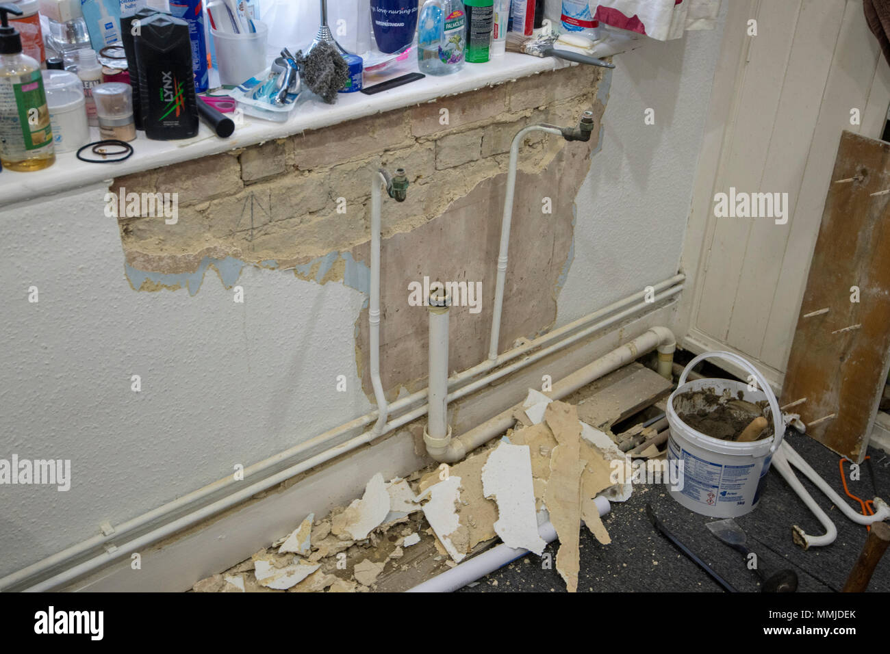 Removed sink, plaster coming off wall Stock Photo - Alamy