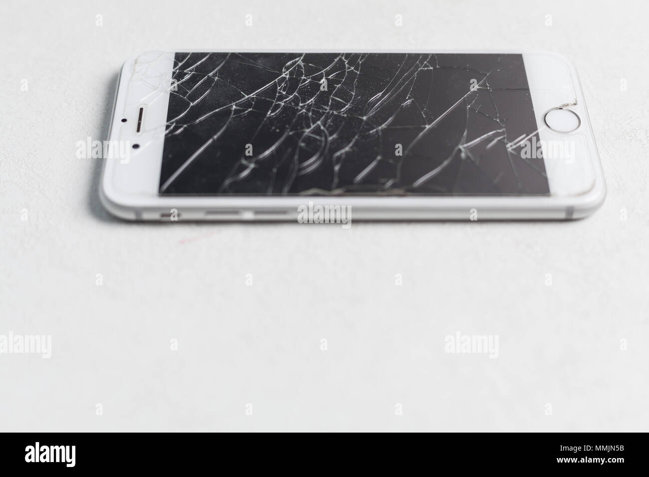 Modern mobile smartphone with broken screen on white background Close ...