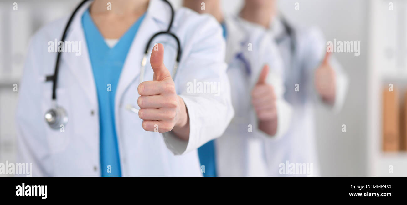 Groupe of medicine doctors show OK sign with thumb up close up. Success ...