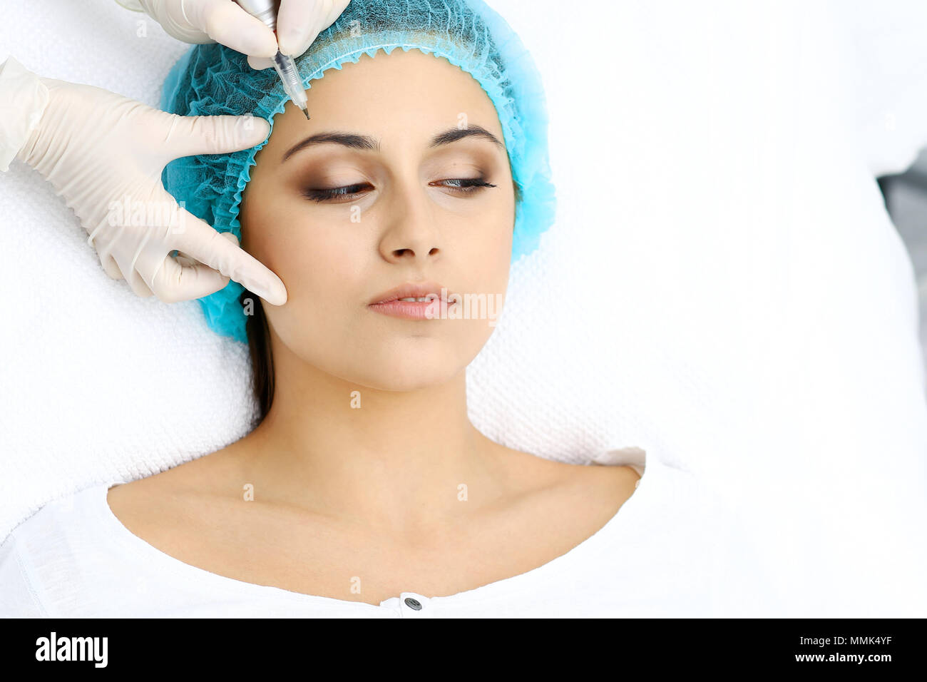 Professional beautician doing eyebrow tattoo at woman face. Permanent ...
