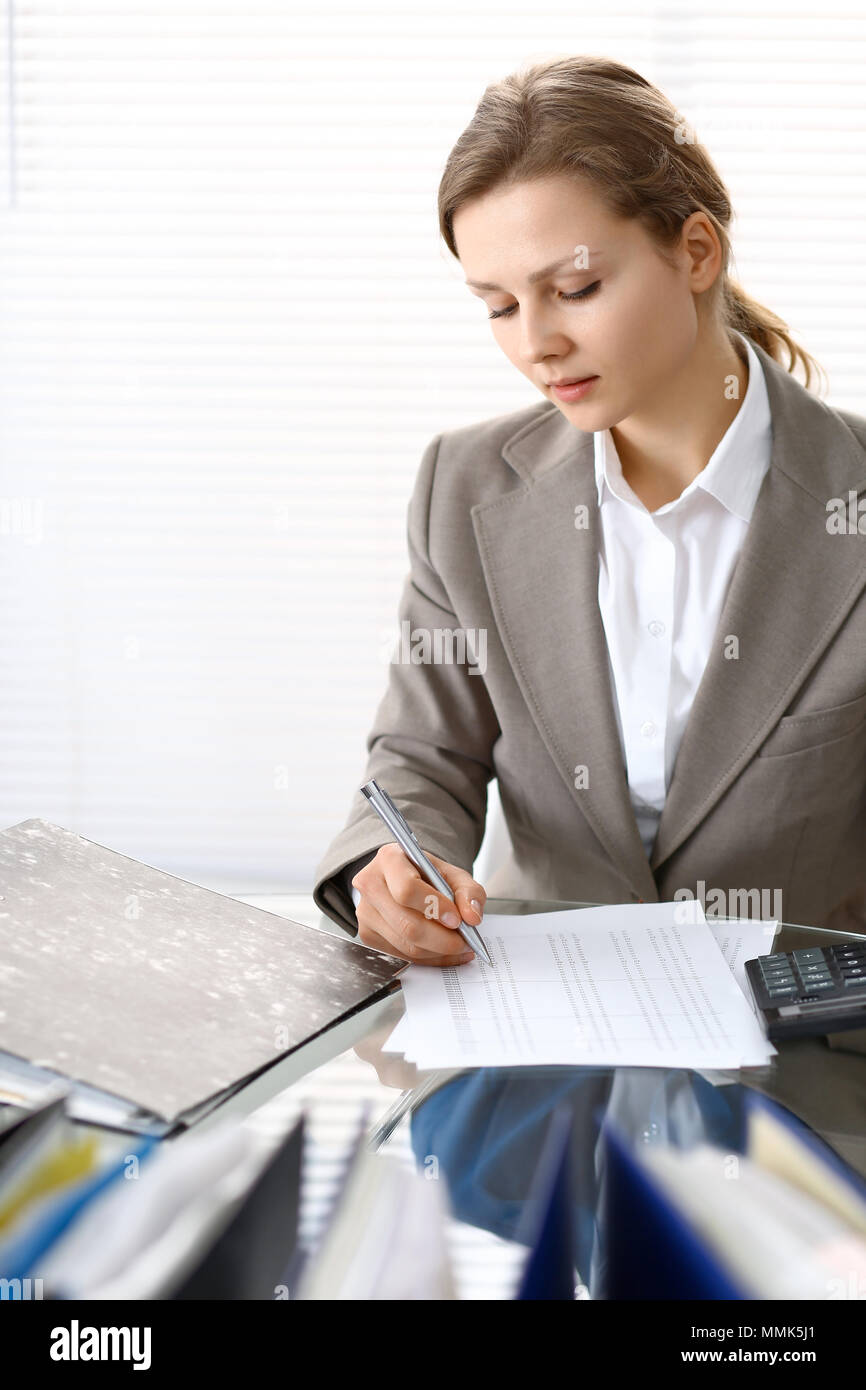Portrait of female bookkeeper or financial inspector making report ...