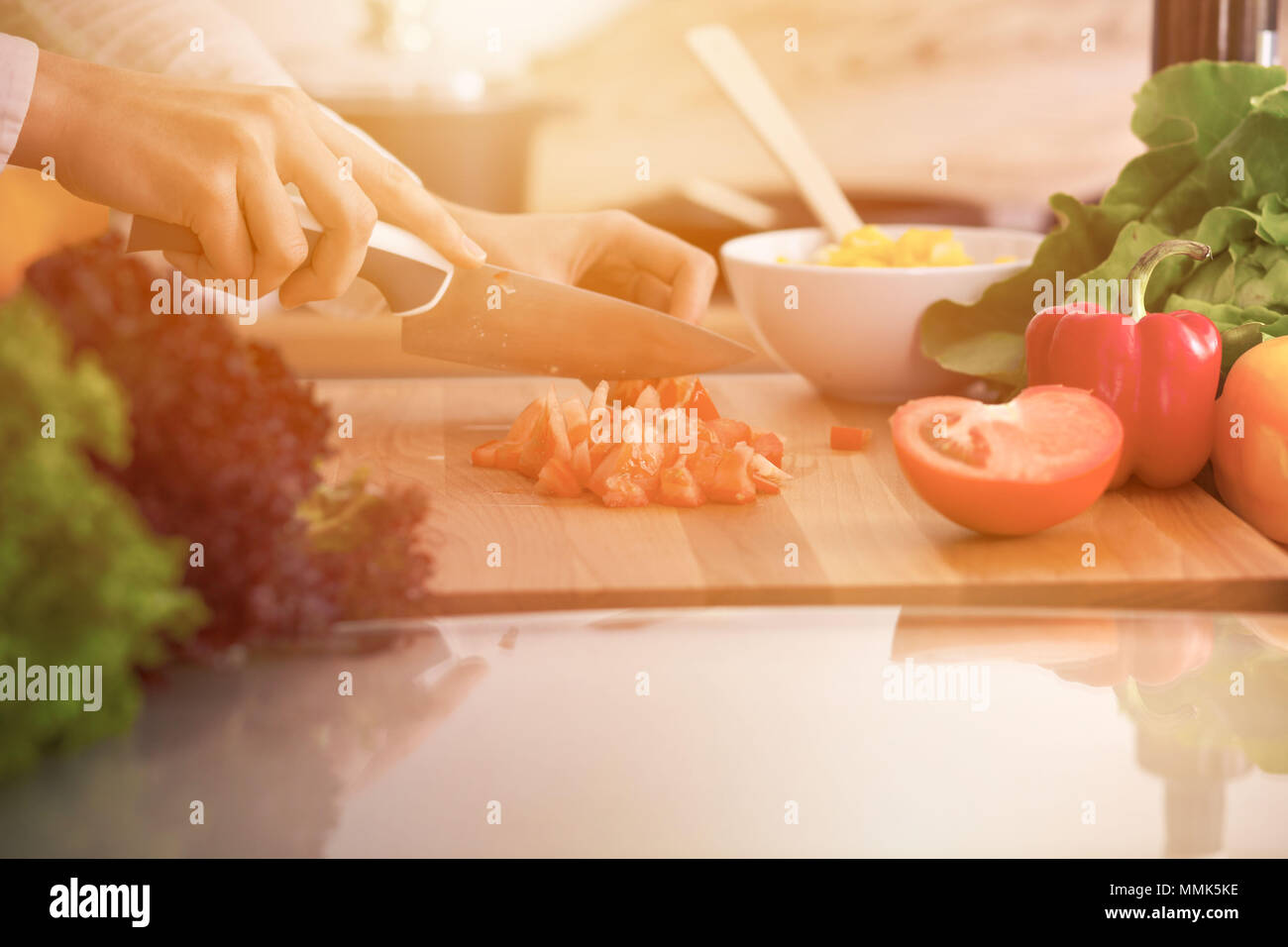 Close Up of human hands cooking vegetable salad in kitchen on the glass ...