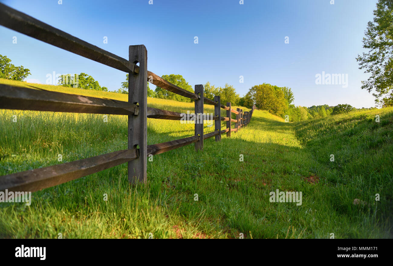 a wooden fence runs along a country road Stock Photo - Alamy