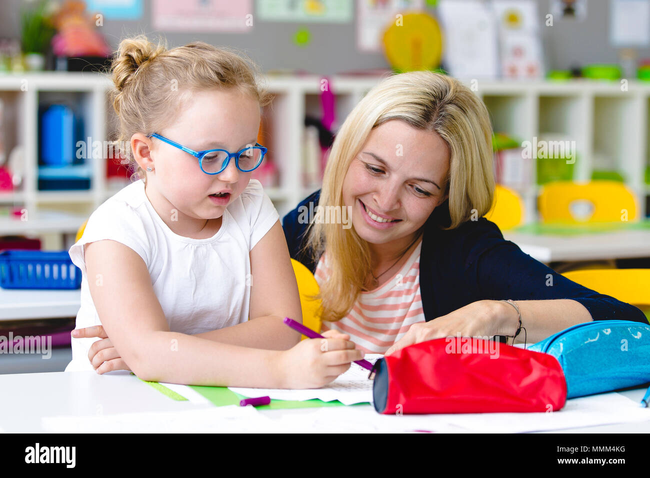 At school - beautiful teacher helps her student to learn Stock Photo ...