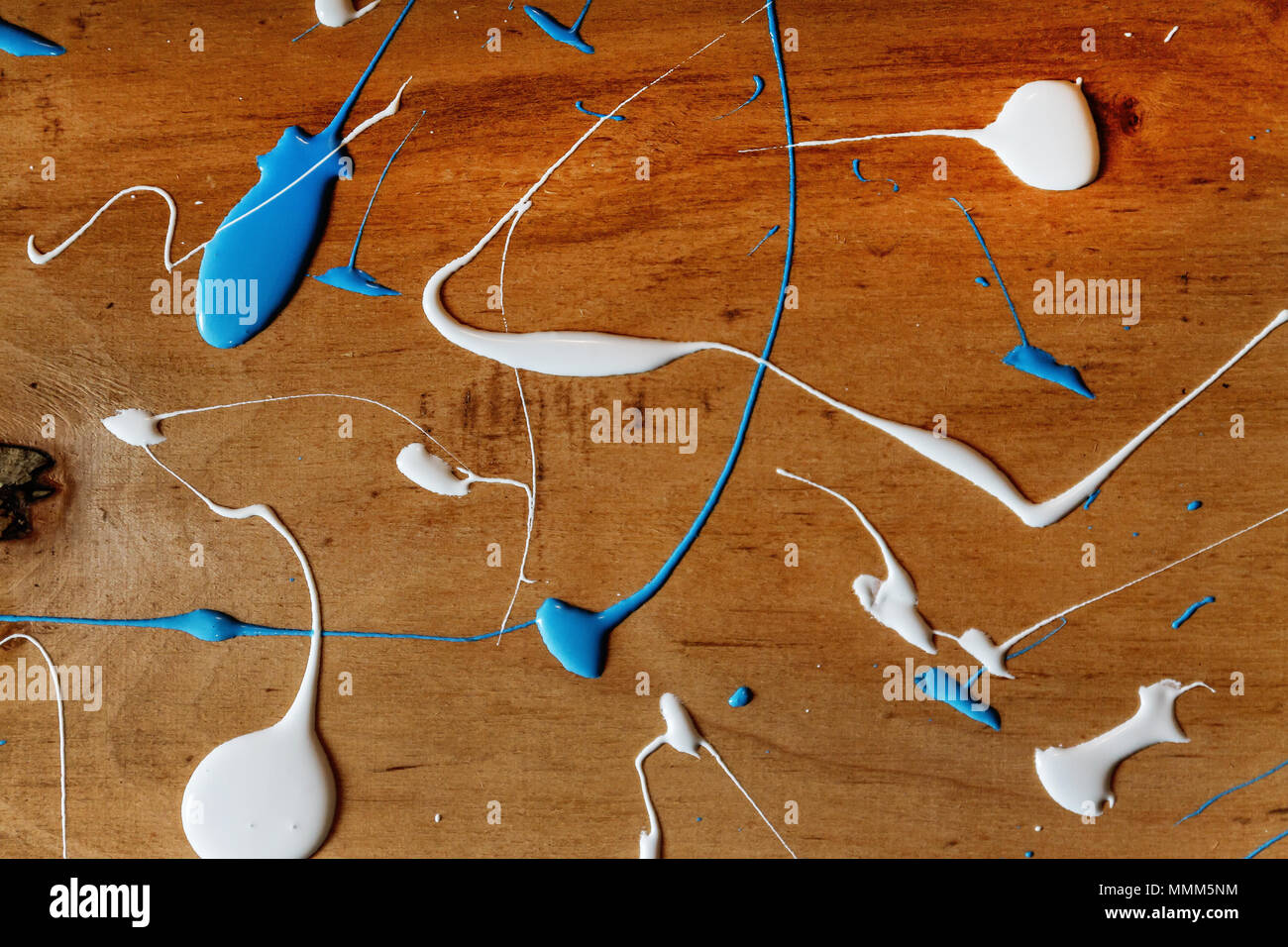 Artist working wooden table top with paint marks spill all over the ...