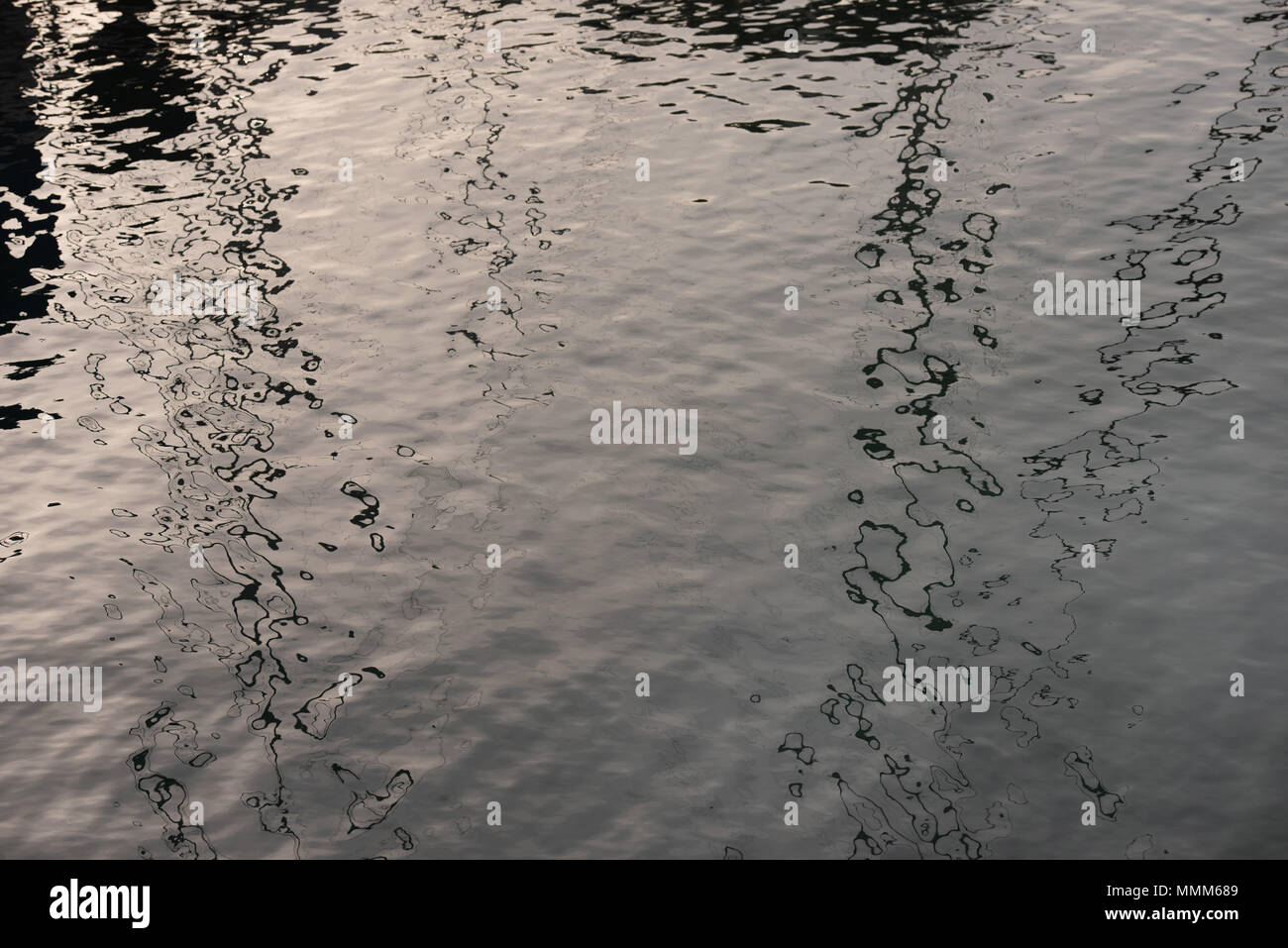 Large puddle, on the gray surface of the water a shallow ripple and ...
