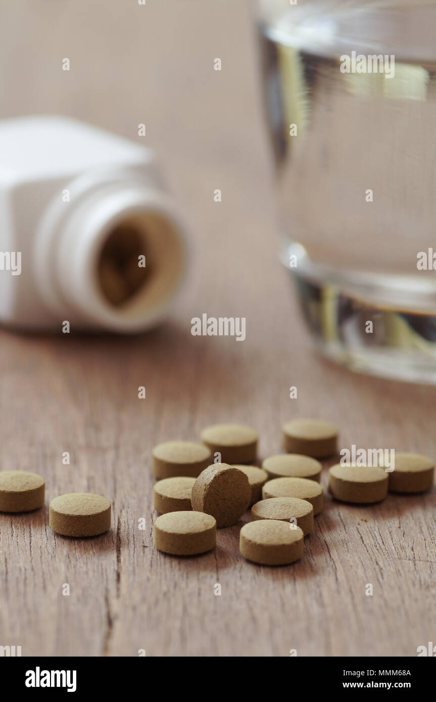 herb medicine in pill on wood background Stock Photo - Alamy