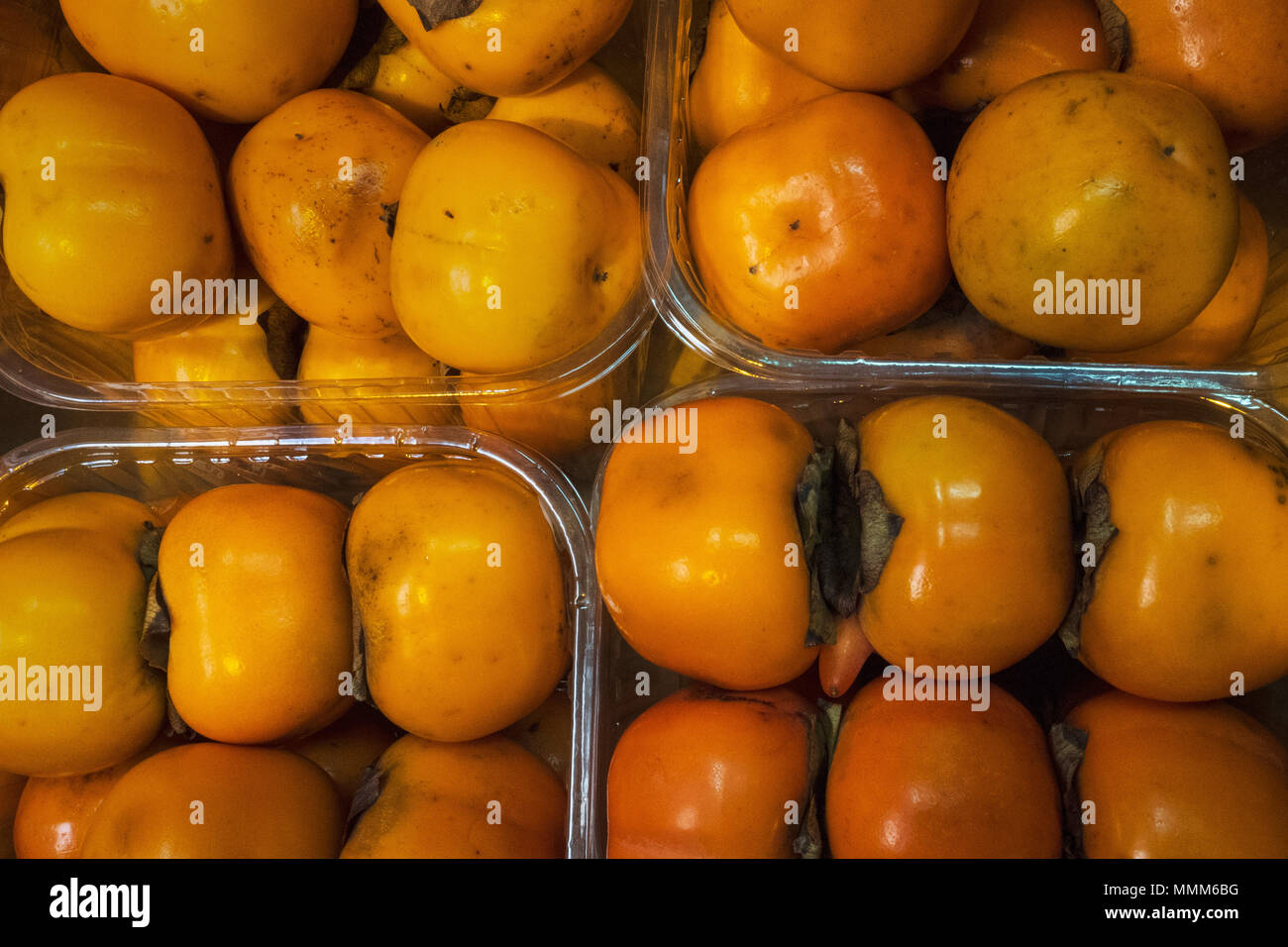 Bright fresh orange persimmons, shiny fruit in plastic boxes for sale ...