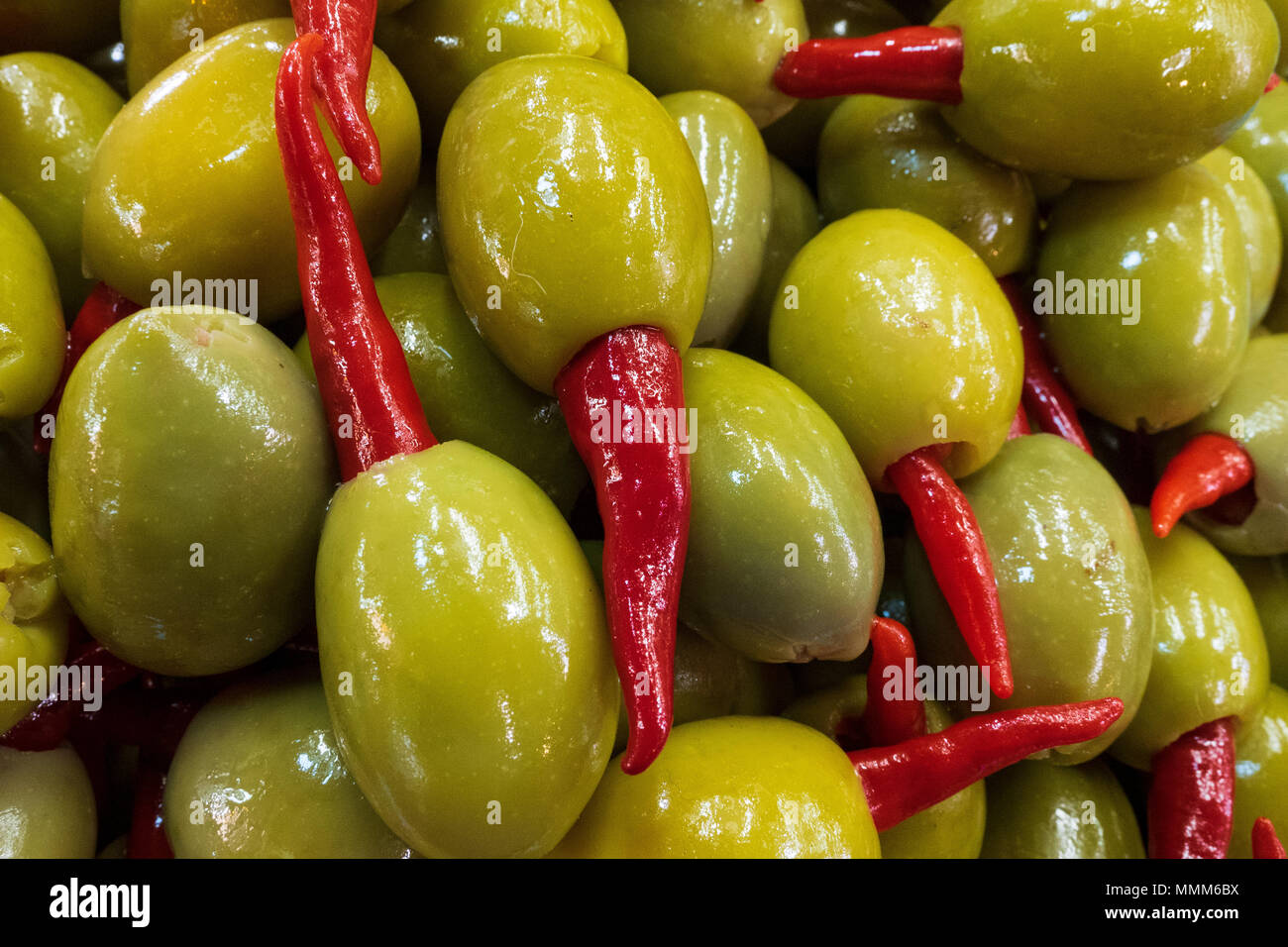 Large shiny olives with red peppers, food background of olives hand ...