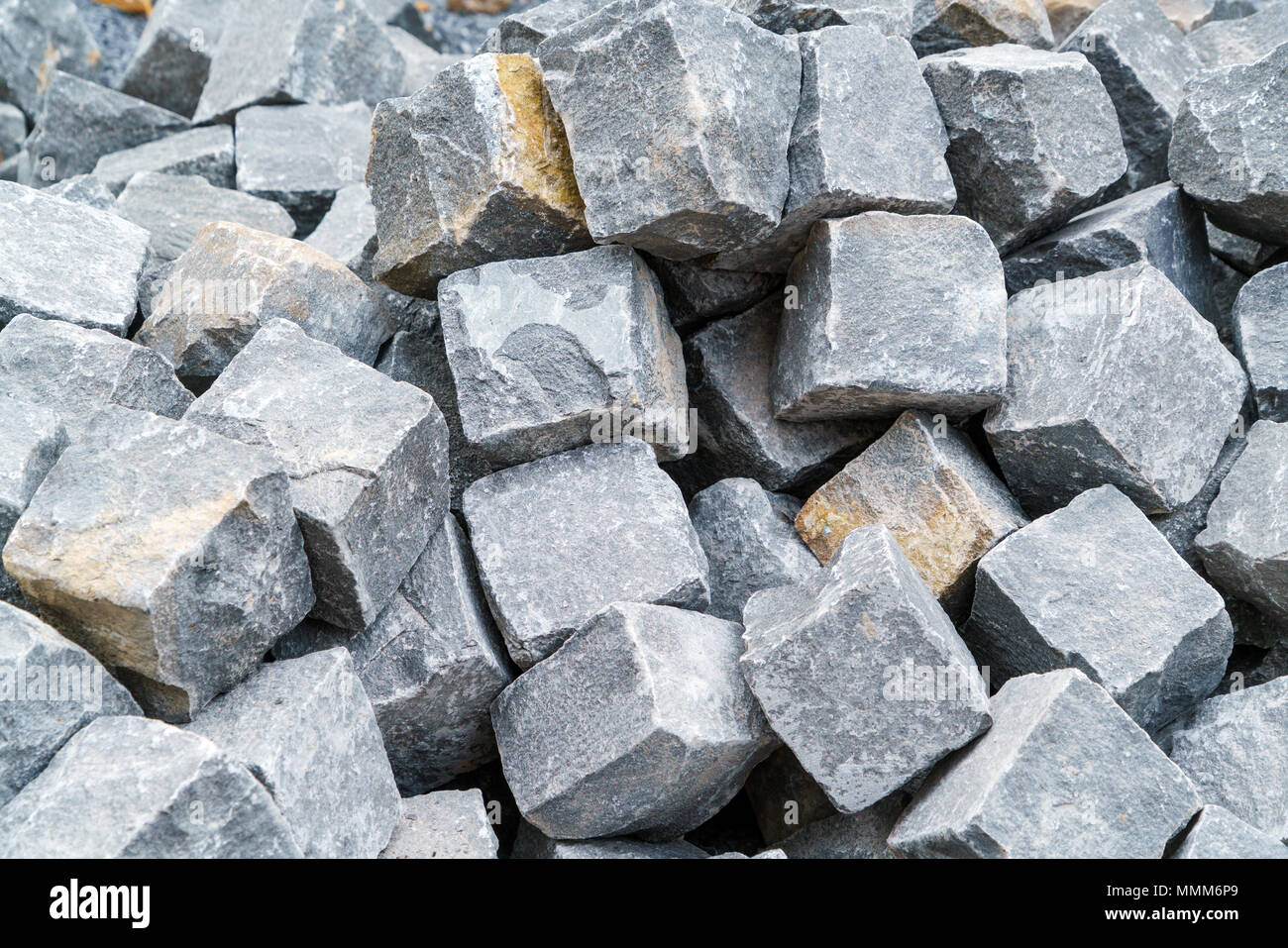A pile of processed pieces of granite prepared for work on paving in ...