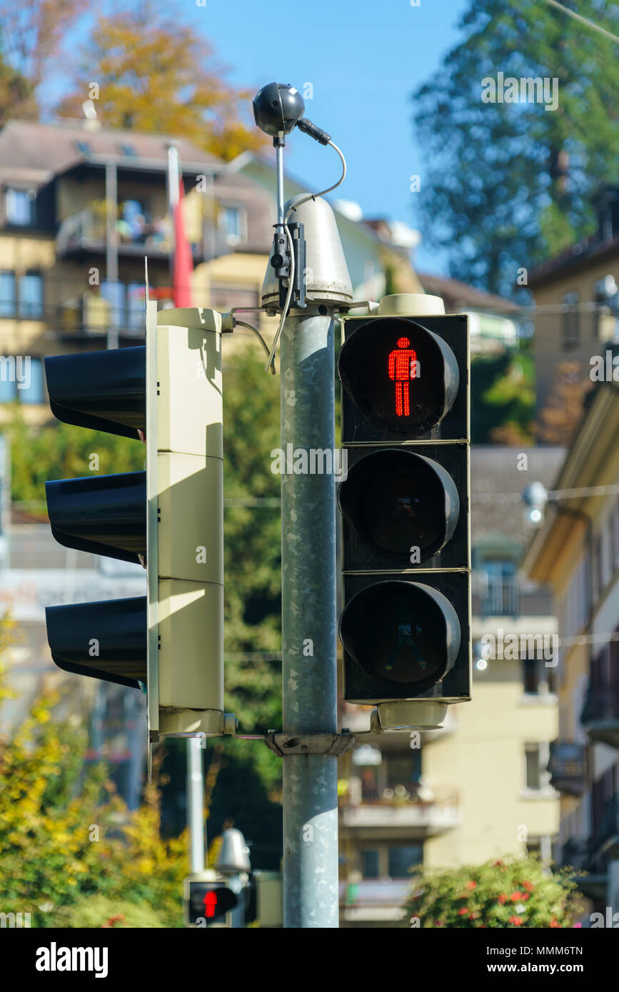 A triple pedestrian traffic light with a burning red man signifying a ...