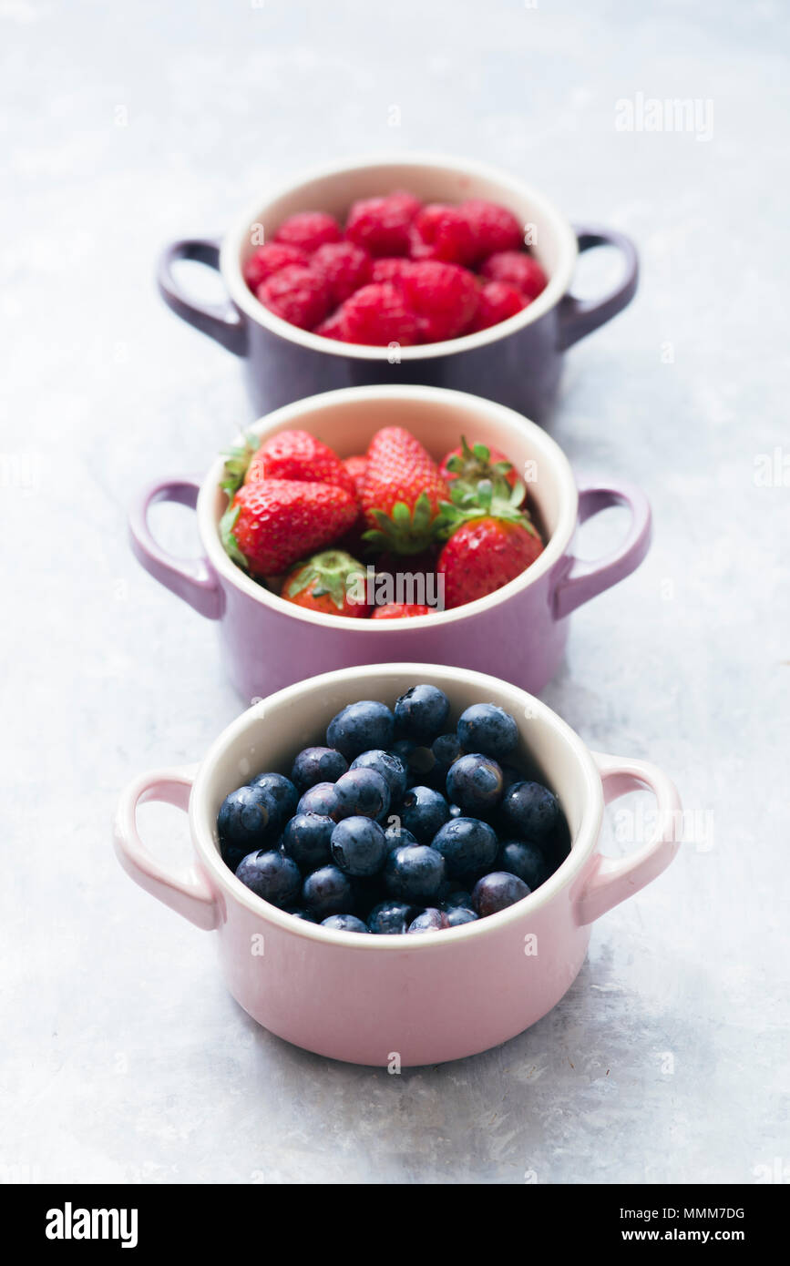 Summer fruit background, top view of berries inside ceramic colored ...