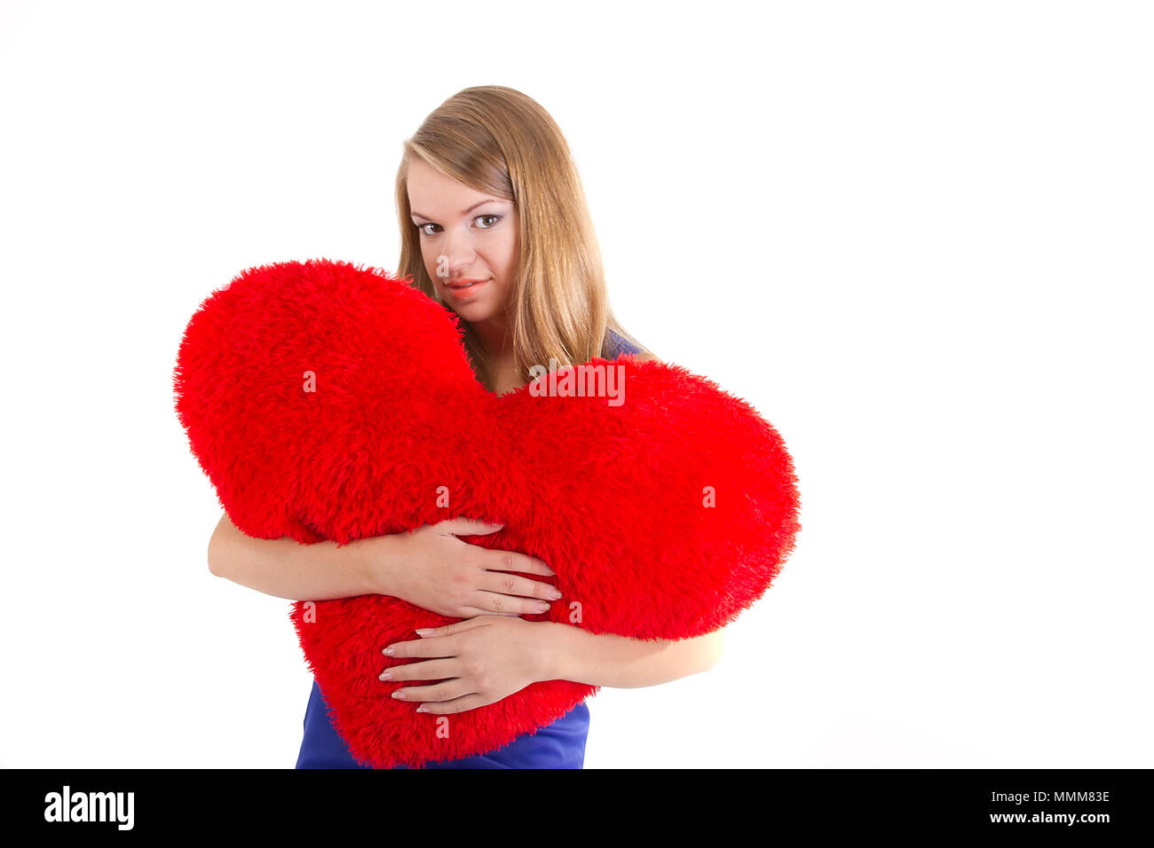 Young beautiful girl hugs a big soft heart. Feast of St. Valentine's ...