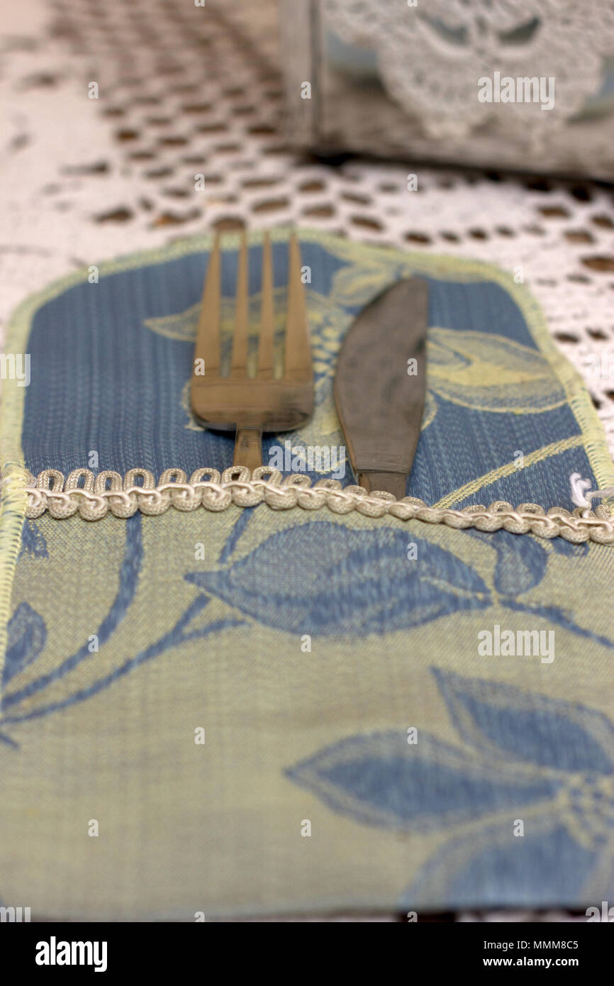 Spoon and fork in tissue wrapper on a light background Stock Photo - Alamy