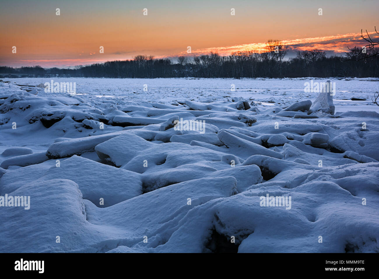 A beautiful snowy winter sunrise along the frozen Maumee river in ...