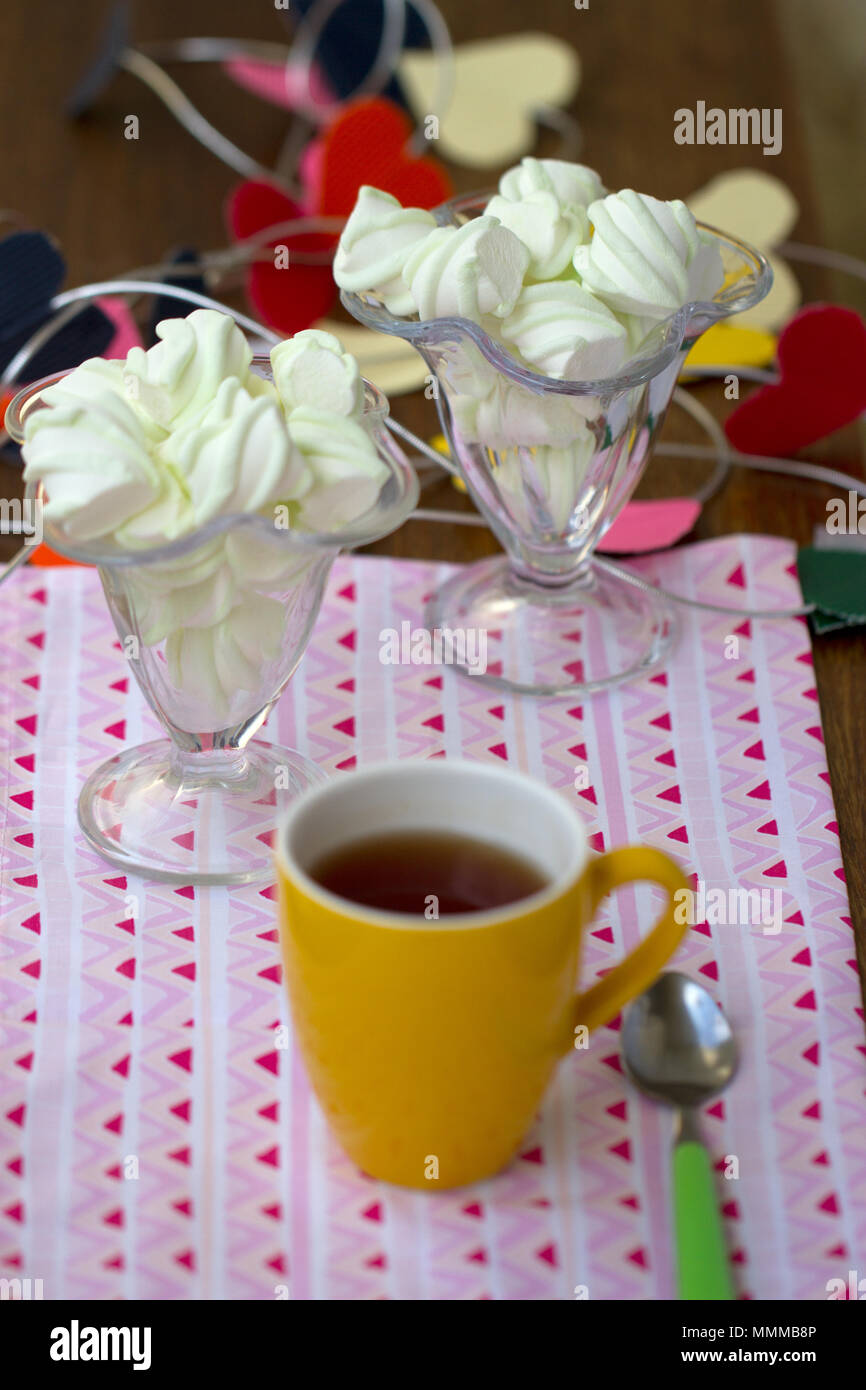 Tea in yellow cup with candy for breakfast Stock Photo - Alamy